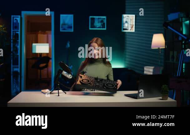 Young artist films DJ mixing tutorial in apartment studio, showing ...