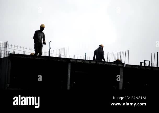 onstruction workers actively building a modern apartment block ...
