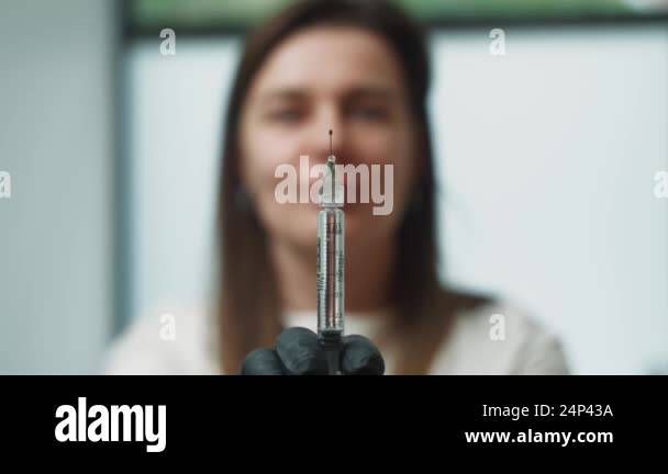 Syringe Needle Dripping Liquid in the Hands of a Doctor Ready for ...