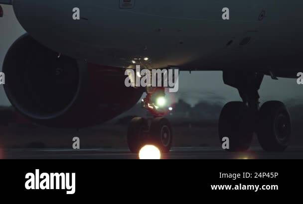 Close-Up of Aircraft Wheels Taxiing on a Nighttime Runway Illuminated ...