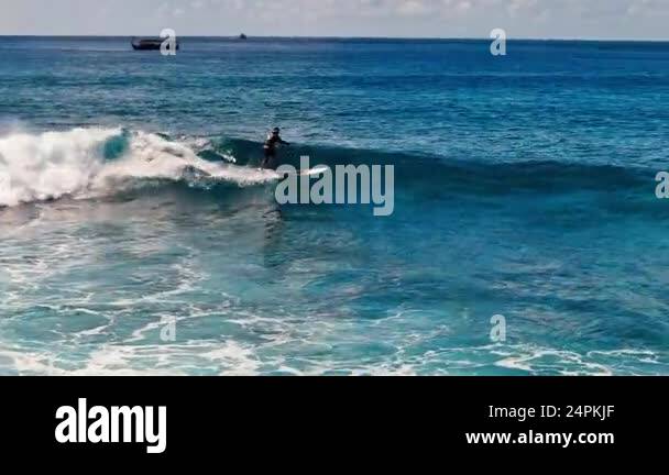 Man surfs the wave. Aerial view of the male surfer riding the wave in ...