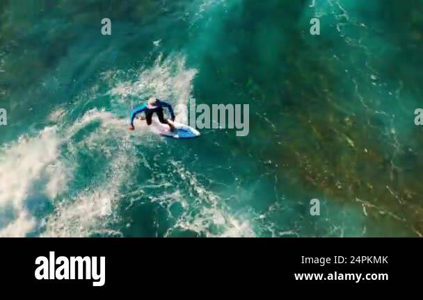 Man surfs the wave. Aerial view of the male surfer riding the wave in ...