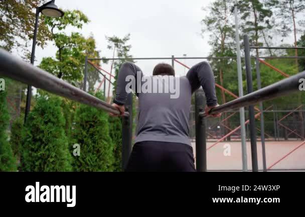 White Caucasian man trains on an outdoor sports field. Man doing ...