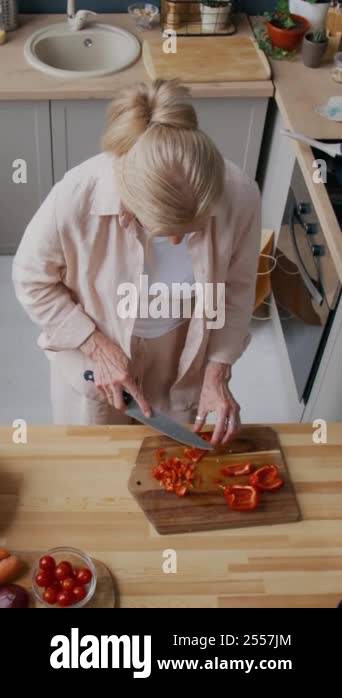 Top-down view shot of Caucasian female chef chopping red bell peppers ...