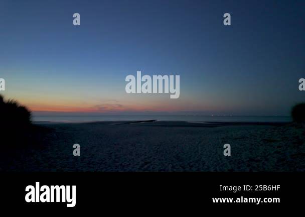 A beautifully tranquil beach scene at twilight, capturing the stunning ...