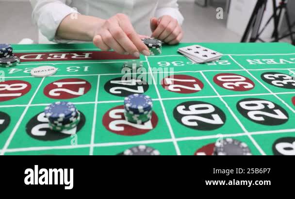 Woman places casino chips on numbers on gaming table. Female player ...
