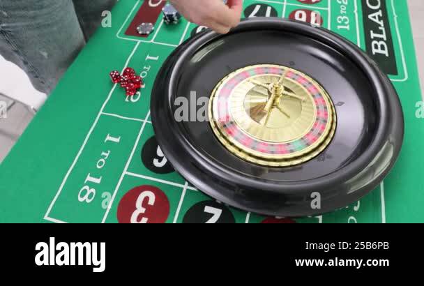 Croupier spins casino wheel signaling start of game. Woman throws ball ...