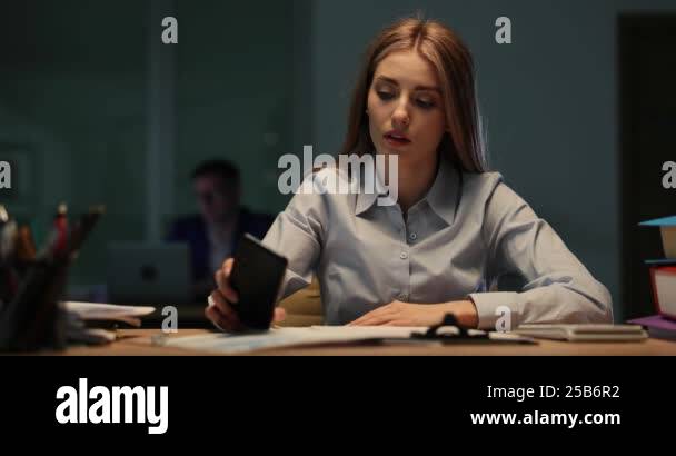 Fatigued woman office clerk watches on time on smartphone and lies down ...