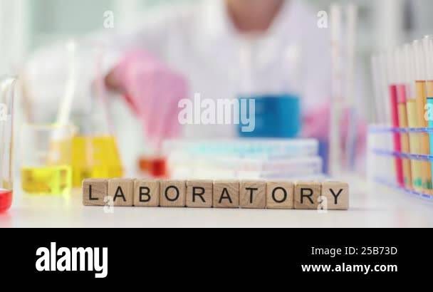 Word Laboratory from wooden cubes against scientist holding test tube ...