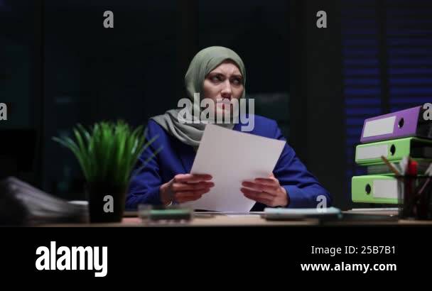 Annoyed businesswoman in hijab examines document. Muslim office worker ...