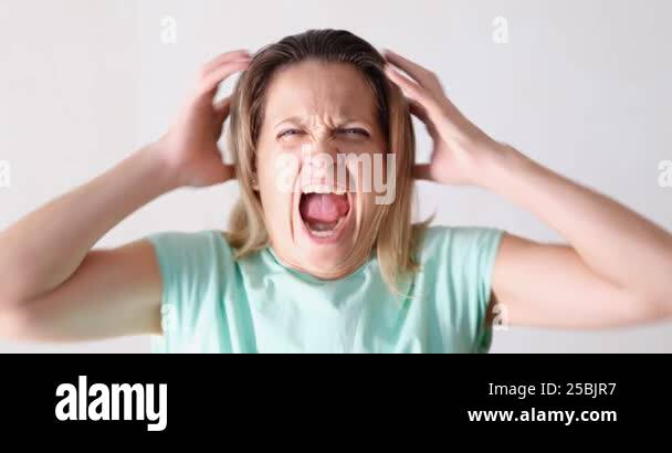 A woman lets out a scream, filled with frustration, expressing deep ...