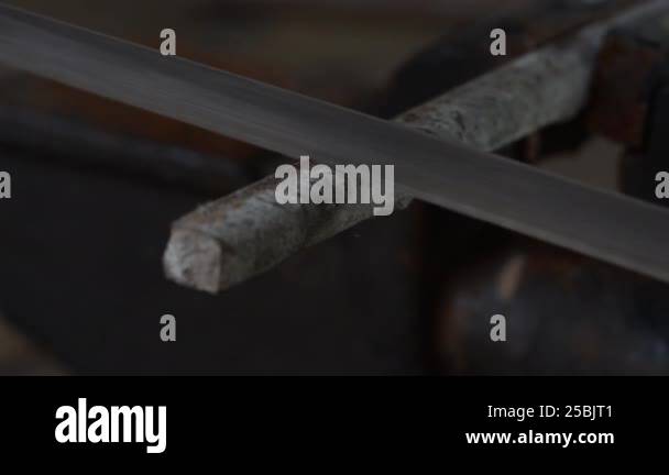 A man saws a metal rod clamped in a vice with a hacksaw, close up Stock ...
