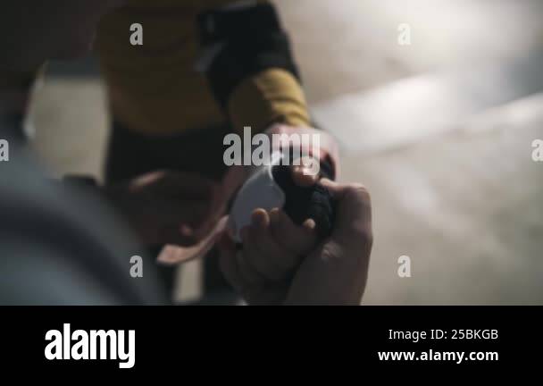 Close-up of adult hands assisting a child in securing protective gear ...