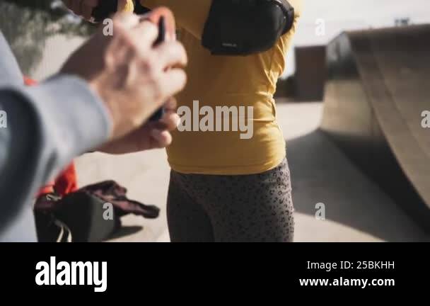 Close-up of adult hands assisting a child in securing protective gear ...