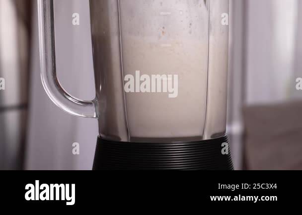 Electric blender mixes ingredients for smoothie, creating bubbles as ...