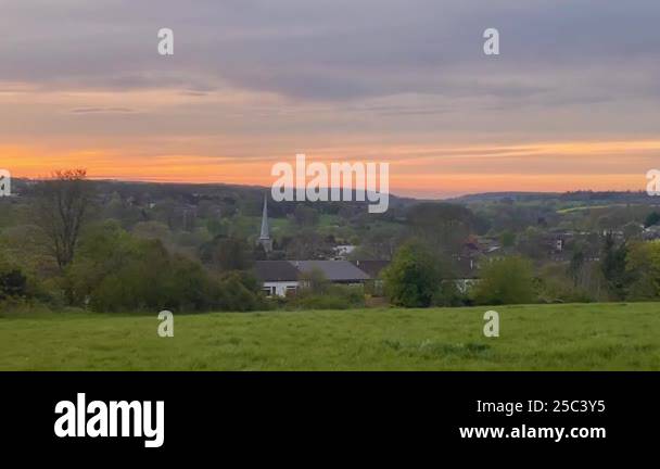 Tranquil English countryside scene at sunset, with rolling green fields ...