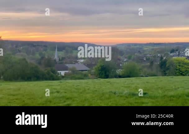 Tranquil English countryside scene at sunset, with rolling green fields ...
