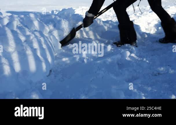 Winter landscape showing woman shoveling snow in slow motion while ...