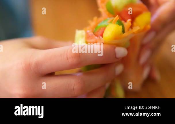 Side view of a sushi chef hands leveling triangle Japanese roll in rice ...
