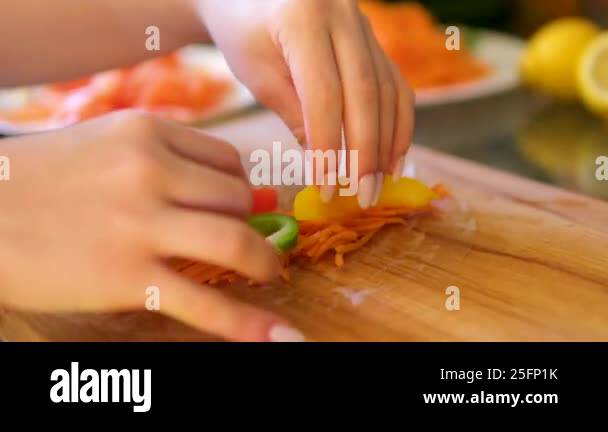 Side view of a sushi chef hands leveling triangle Japanese roll in rice ...