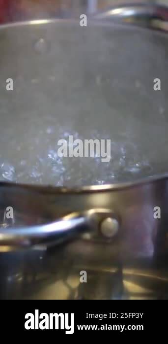 Steam and hot water bubbles rising from boiling hot water on black ...