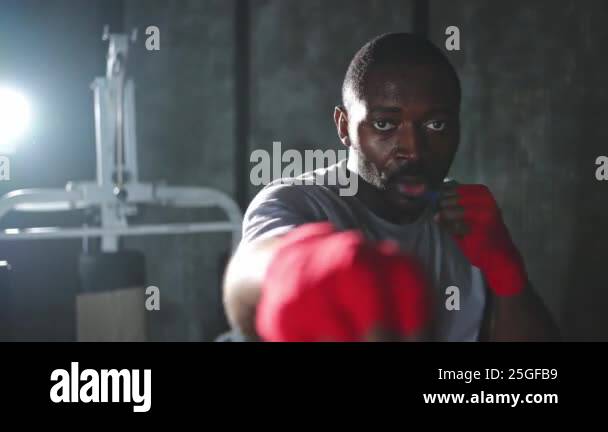 Workout in gym. African man fighter ready for fight punching with ...