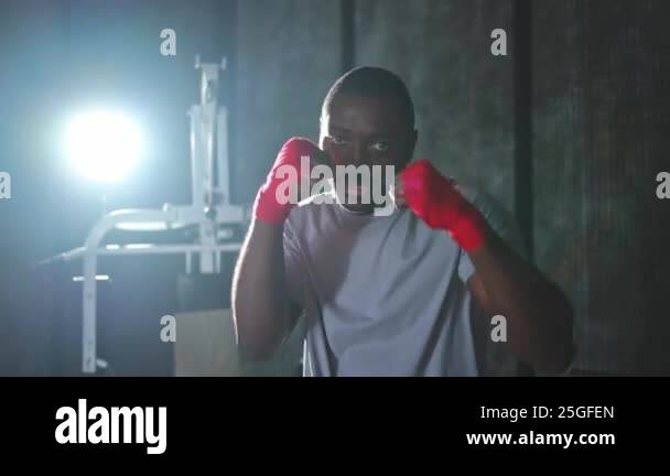 Workout in gym. African man fighter ready for fight punching with ...