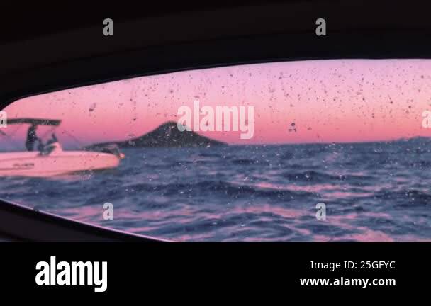 View from the ship's window porthole on the sea. A yacht sailing on the ...