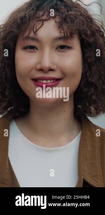 Vertical Video. Portrait Of Curly Young Asian Girl Standing Outdoors With Toothy Smile Enjoying ...