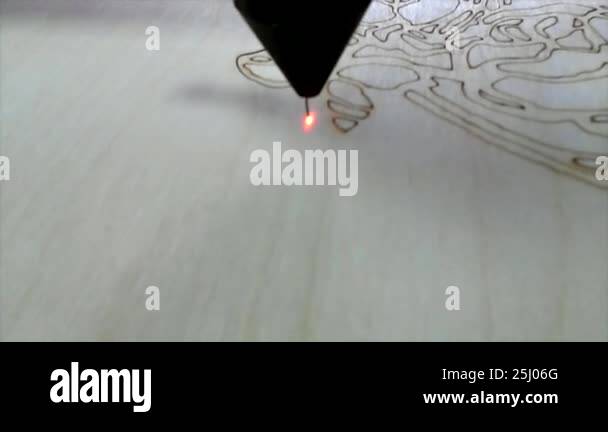 Laser engraving machine creating intricate patterns on a wooden surface ...