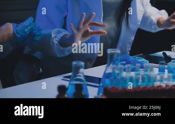close up of hands of a scientist holding test tube in a laboratory ...
