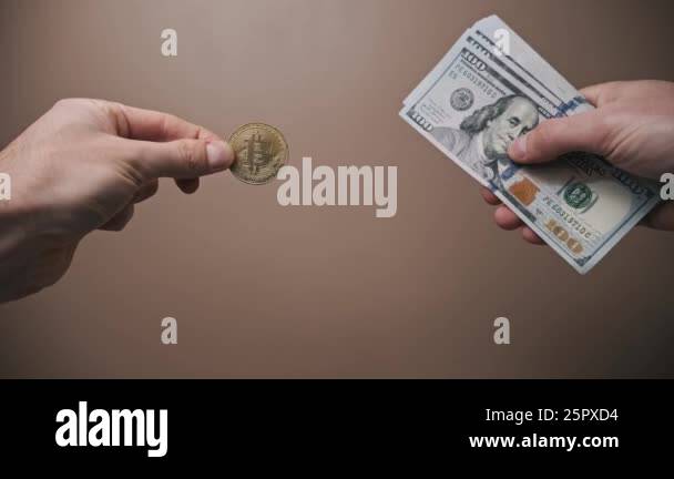 A golden bitcoin coin juxtaposed with several hundred dollar notes ...