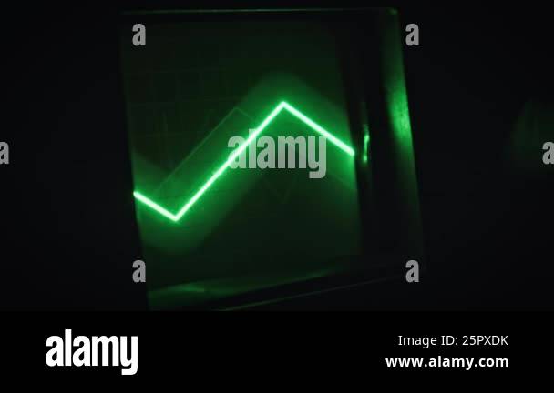 A vintage oscilloscope displays dynamic green sine waves, oscillating ...