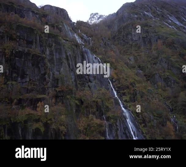 A stunning waterfall cascading down rugged cliffs that are beautifully ...