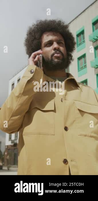 Vertical low angle shot of Biracial businessman with beard in yellow ...