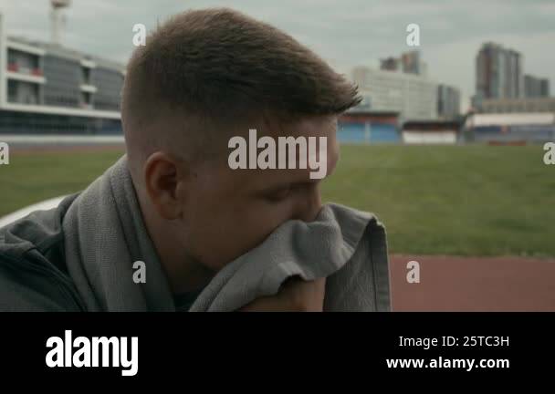 Medium closeup of tired young Caucasian male athlete with crew cut ...