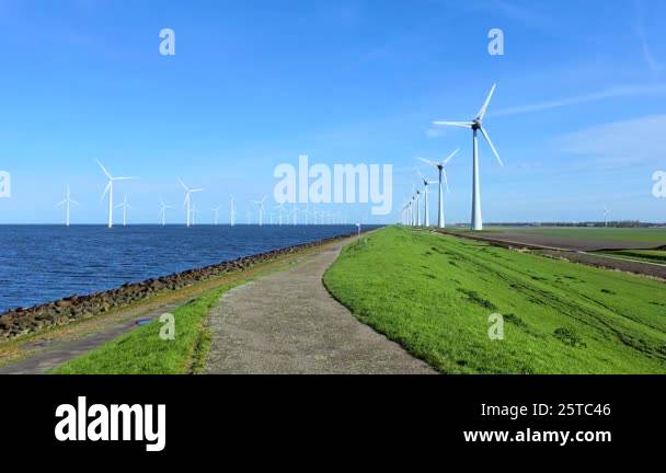 Experience the beauty of the Dutch countryside as wind turbines line ...