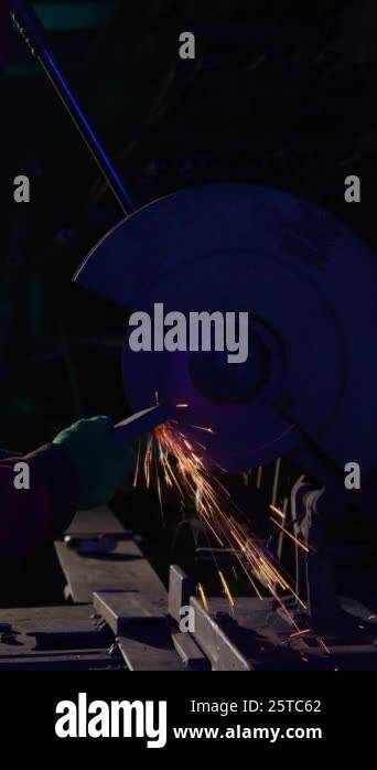 Professional blacksmith grinds metal detail edges with lathe machine at ...