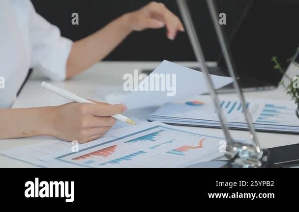 close up of woman hand working on paper document and pen at the office ...