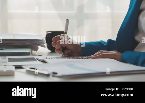 business woman writing on notebook and working with documents on table ...