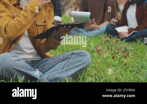 young asian woman using tablet computer in the park. young people use ...