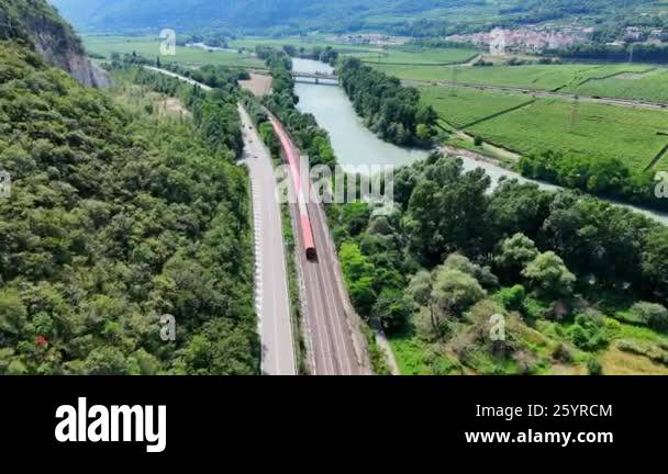 Red train is traveling through the french countryside, passing cars on ...