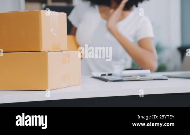 young woman working on laptop and packing boxes Stock Video Footage - Alamy