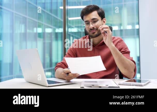 Overworked handsome bearded businessman is tired of doing paperwork ...