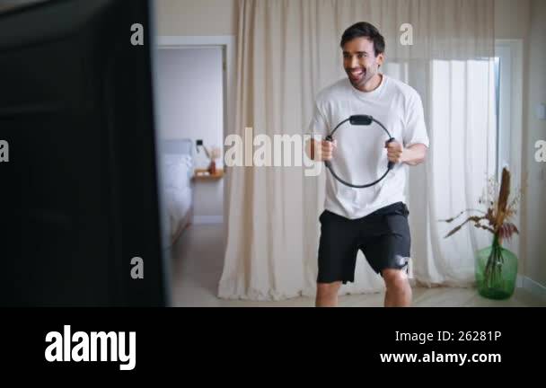 Active man using pilates ring at energetic workout home. Smiling guy ...