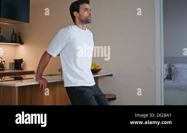 Motivated man performing dips on kitchen counter at strength training ...