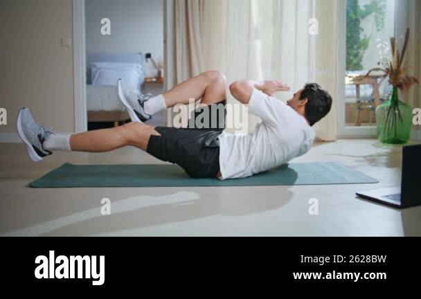 Sport man performing crunches on yoga mat at home morning workout ...