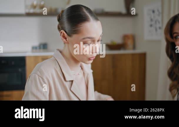 Women chatting at kitchen table smiling happily closeup. Two trendy ...