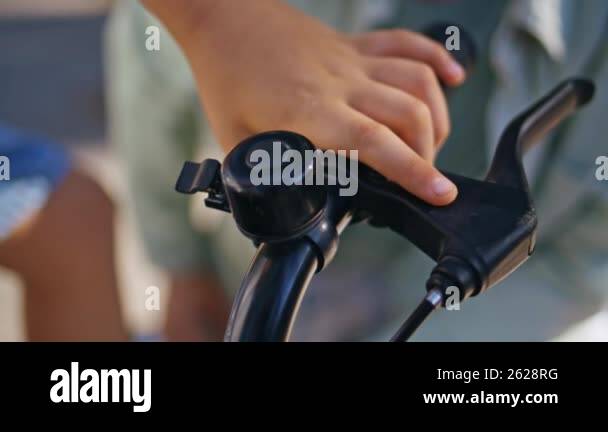 Kid hands touching bicycle outdoors closeup. Unrecognizable small boy ...