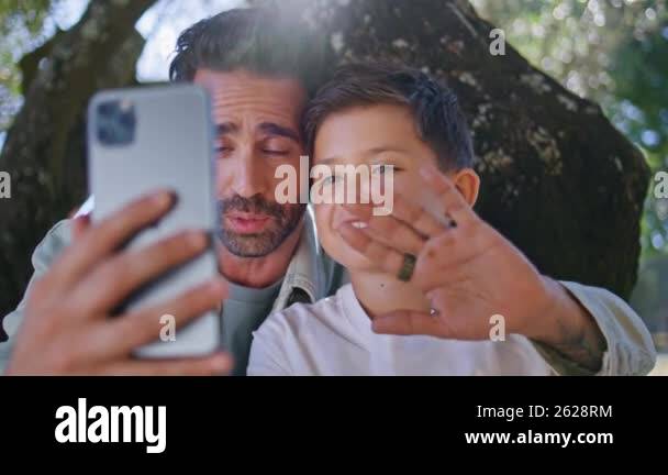 Closeup family calling cellphone under tree at garden. Handsome young ...